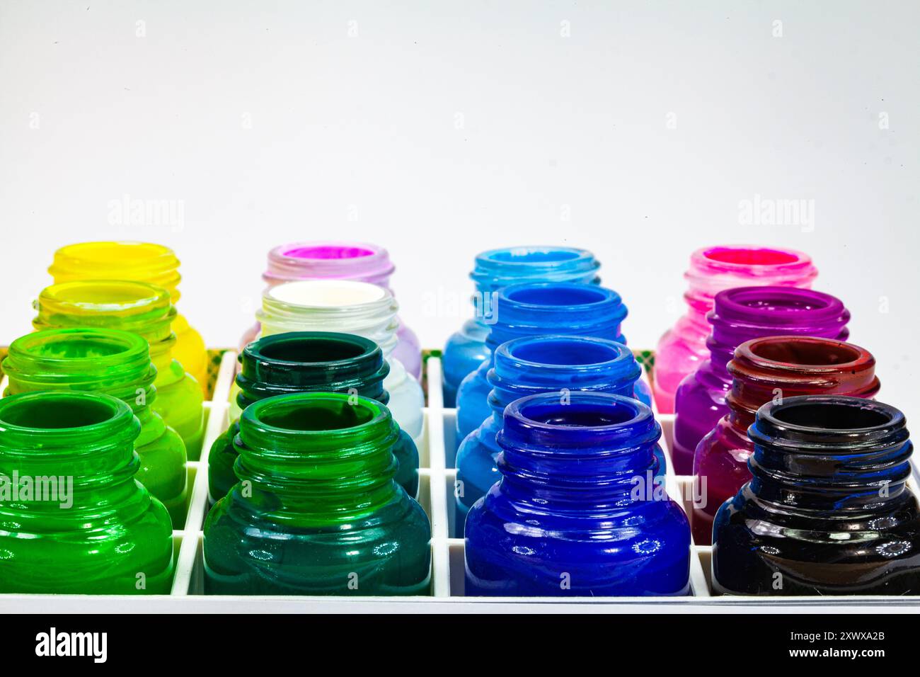 A vibrant display of various colored ink bottles arranged in a grid ...