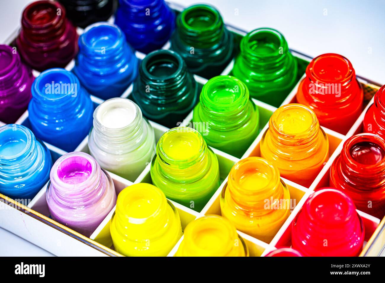 A vibrant display of various colored ink bottles arranged in a grid ...