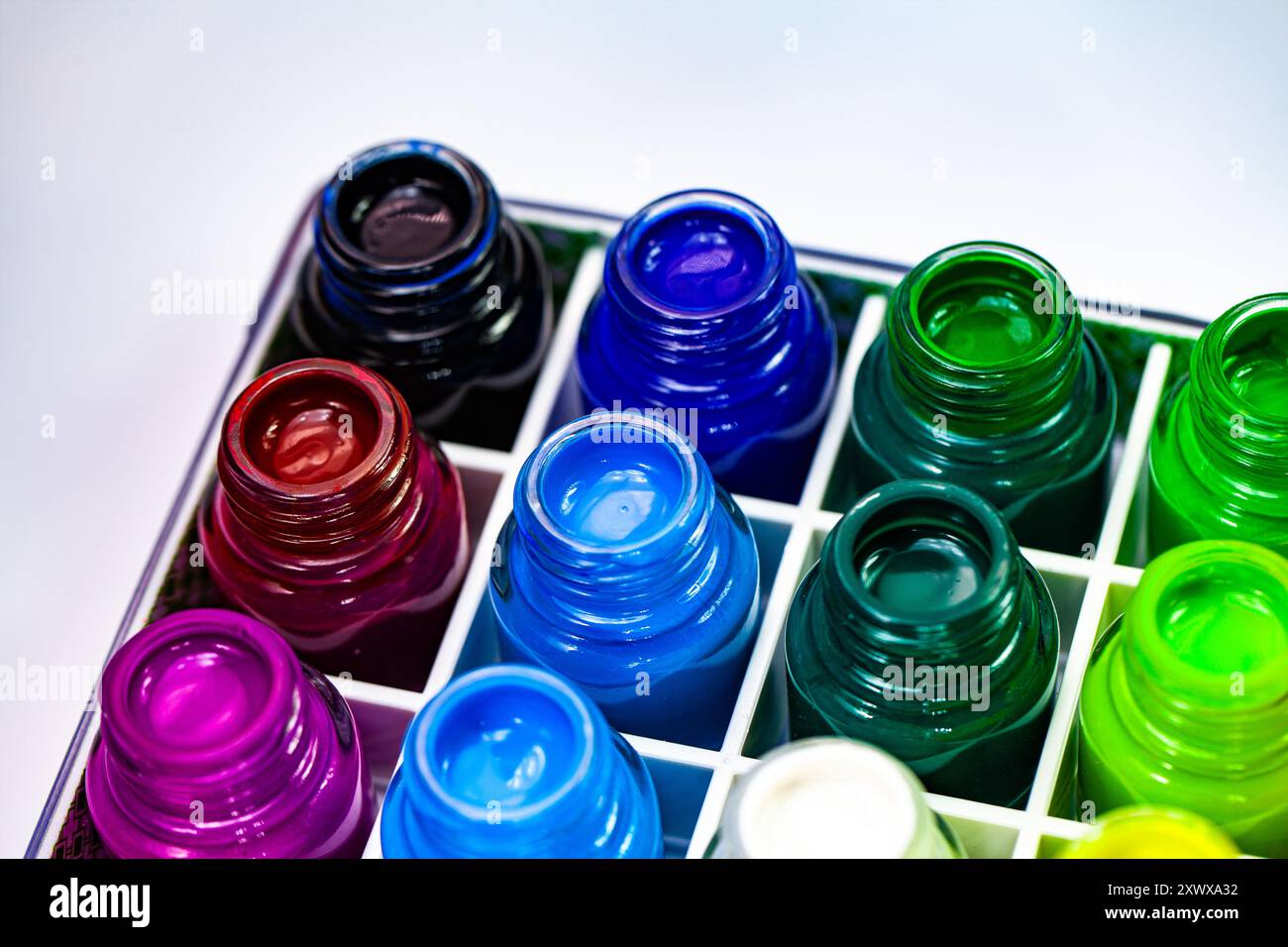 A vibrant display of various colored ink bottles arranged in a grid ...