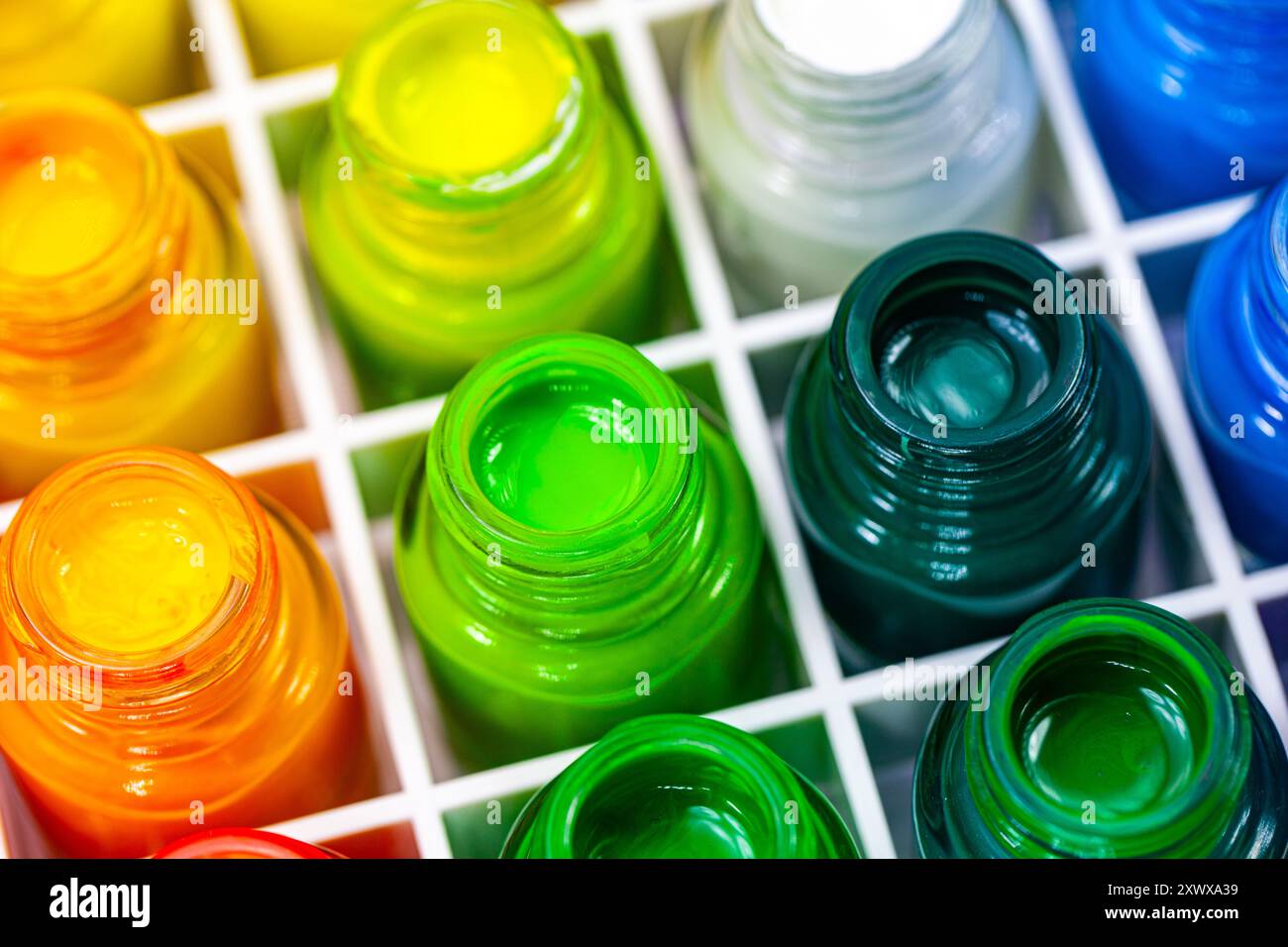 A vibrant display of various colored ink bottles arranged in a grid ...