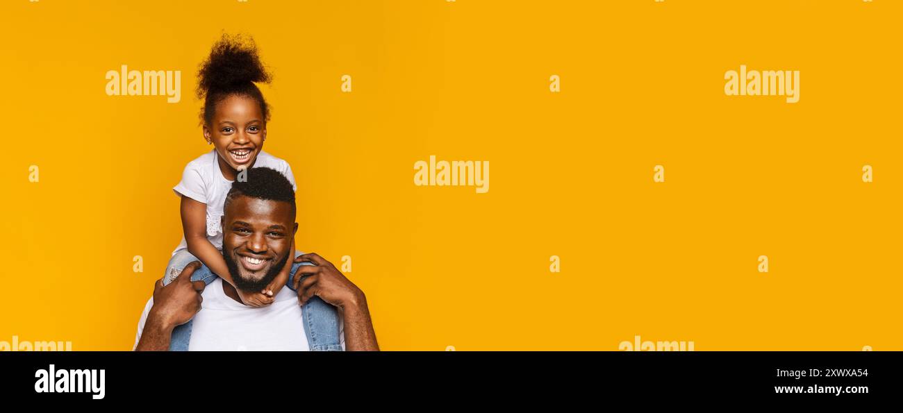 Joyful Father and Daughter Playfully Smiling Against Yellow Background ...