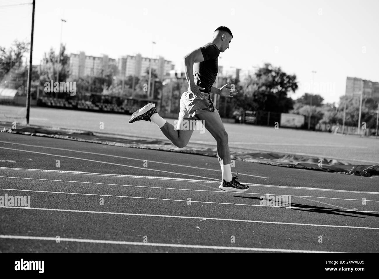 Monochrome photo. Athlete man in uniform, sprinter running in motion on ...