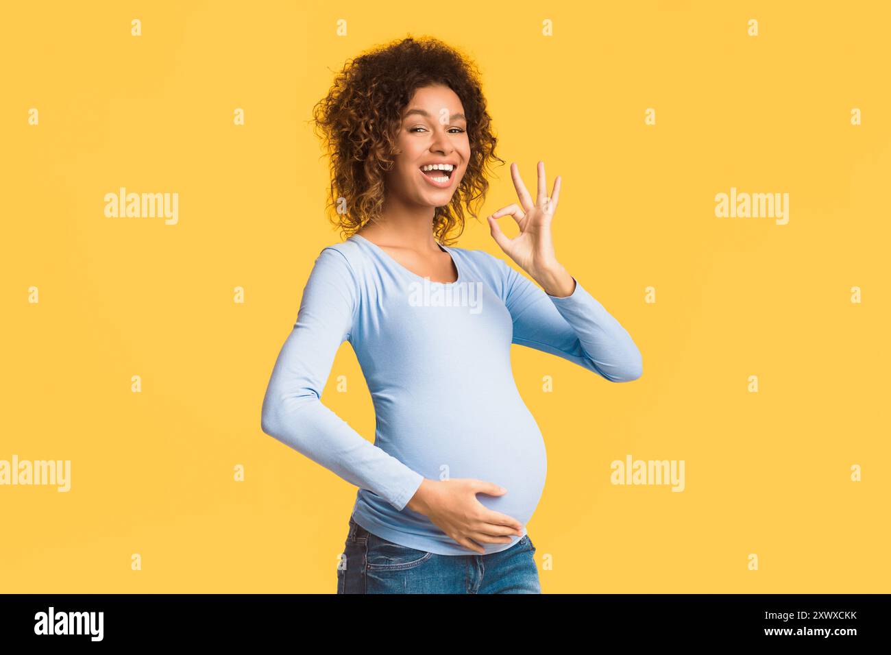 Excited afro pregnant woman showing OK gesture Stock Photo - Alamy