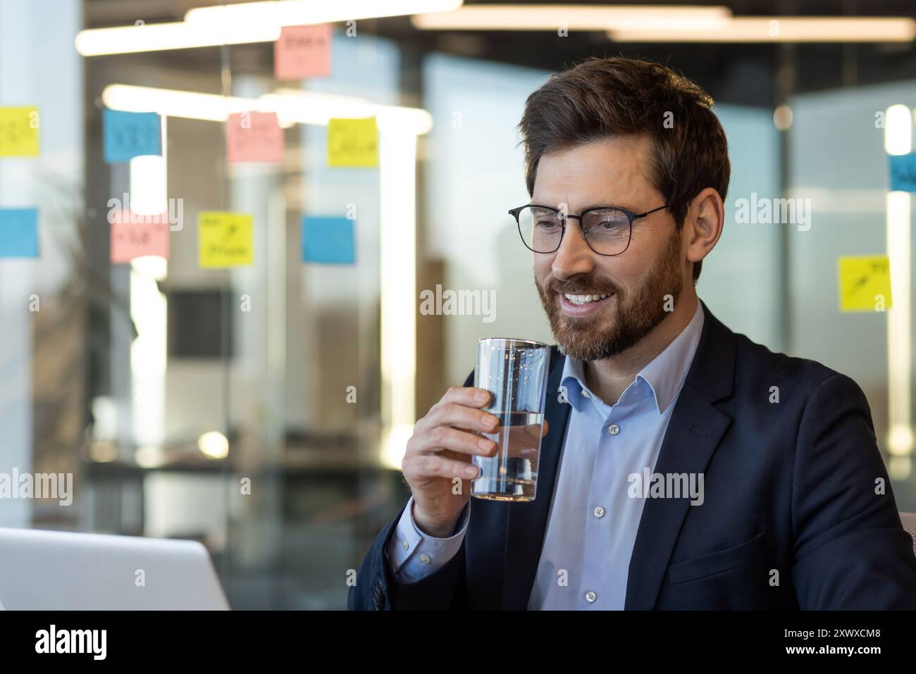 Confident businessman wearing suit and glasses enjoying refreshing ...