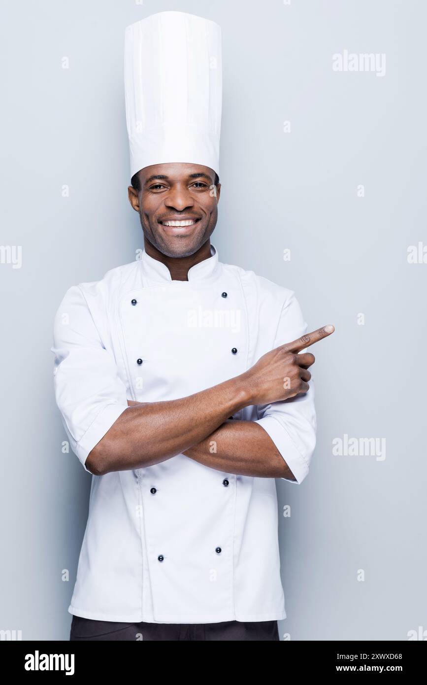 Special offer from chef. Confident young African chef in white uniform ...