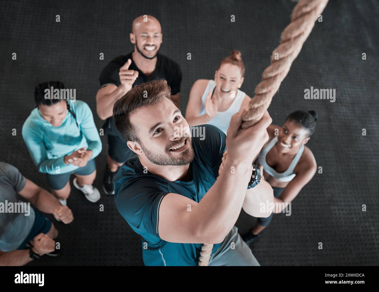 Climbing, rope and man in gym, fitness and coach with timer, group and ...