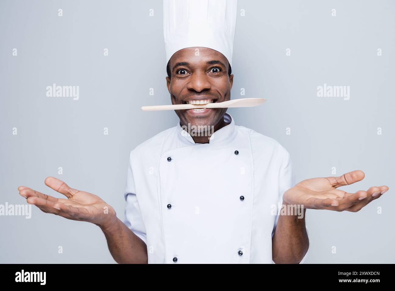 Surprised chef. Surprised young African chef in white uniform holding ...