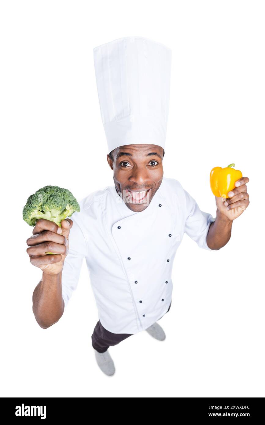 Cooking healthy food. Top view of excited young African chef in white ...