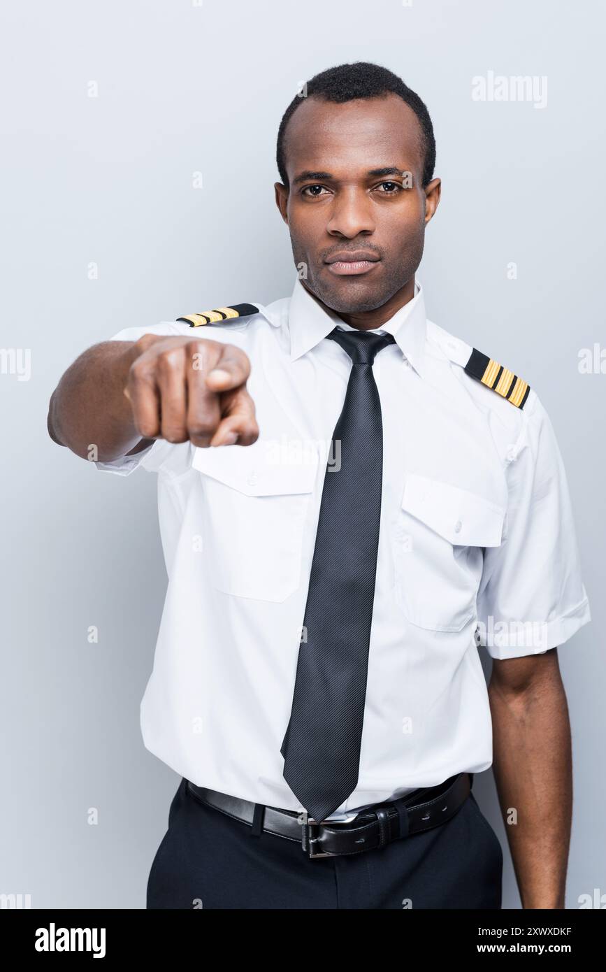 Serious pilot. Serious African pilot in uniform pointing the camera ...