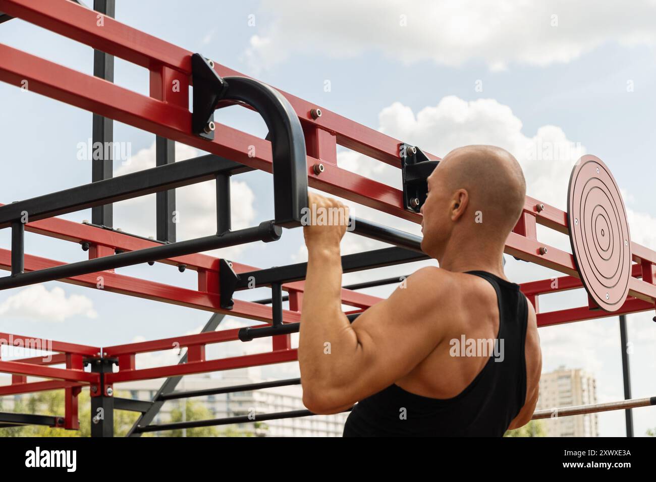Athlete muscular fitness male pulling up on horizontal bar at street ...