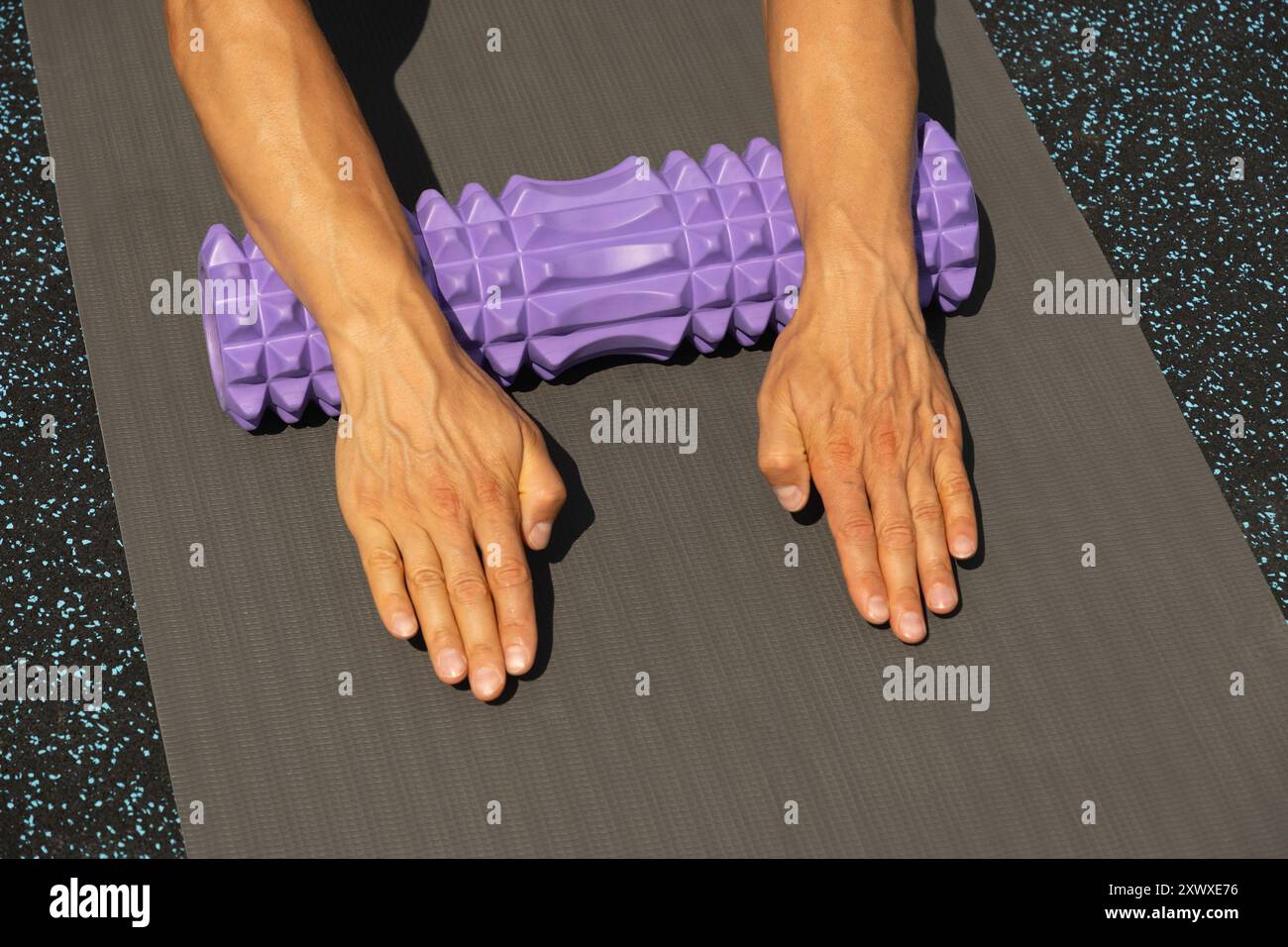 Athlete mans hands exercising and stretching arms on foam roller on ...