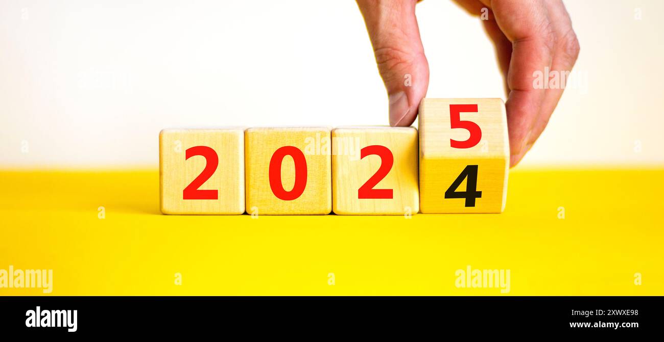 Business concept of 2025 new year symbol. Businessman turns wooden cube and changes number 2024 ...