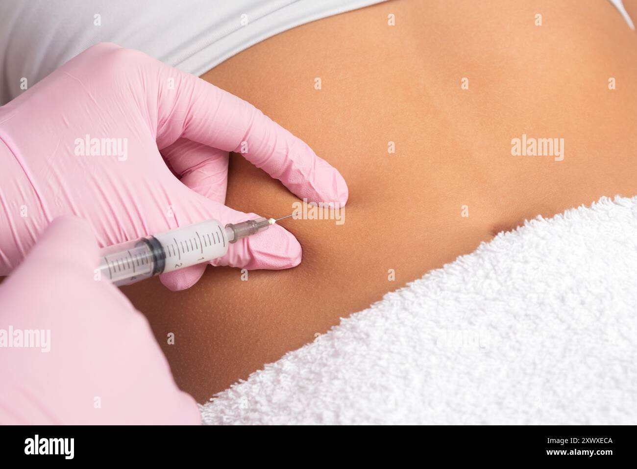 A doctor of aesthetic cosmetology makes lipolytic injections to burn ...