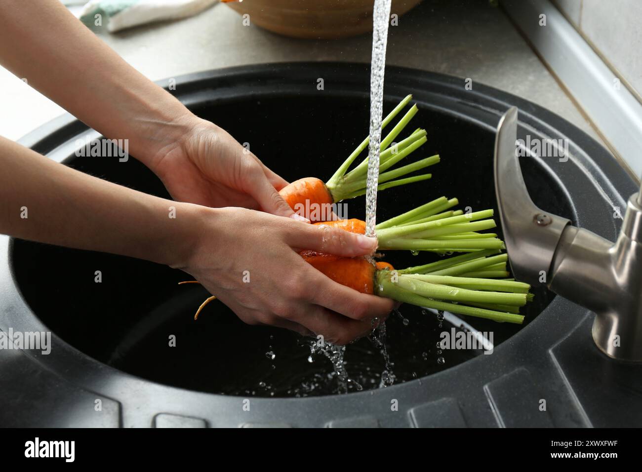 Woman washing fresh carrot under hi-res stock photography and images ...