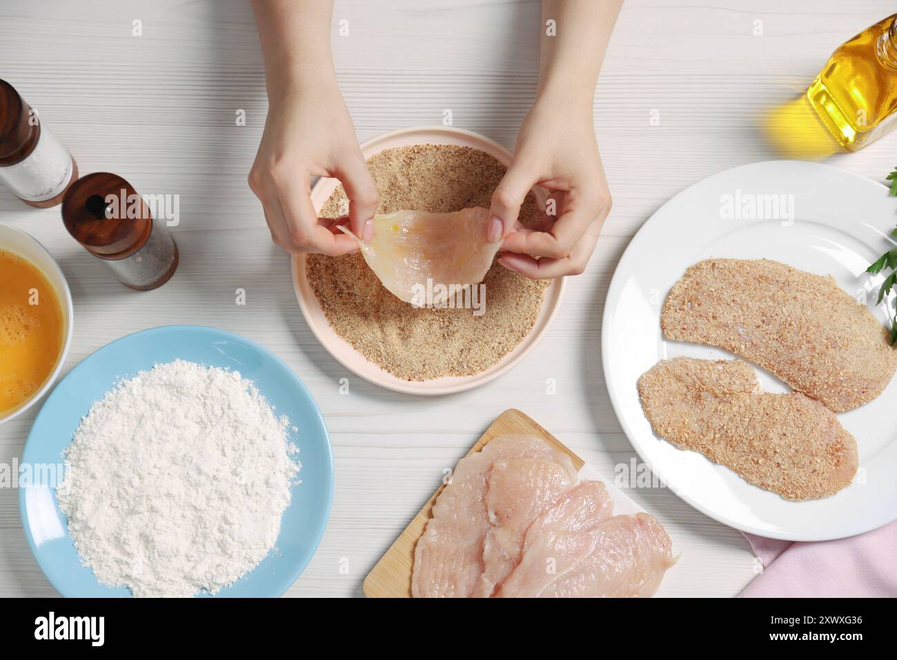 Making schnitzel. Woman coating slice of meat with bread crumbs at ...