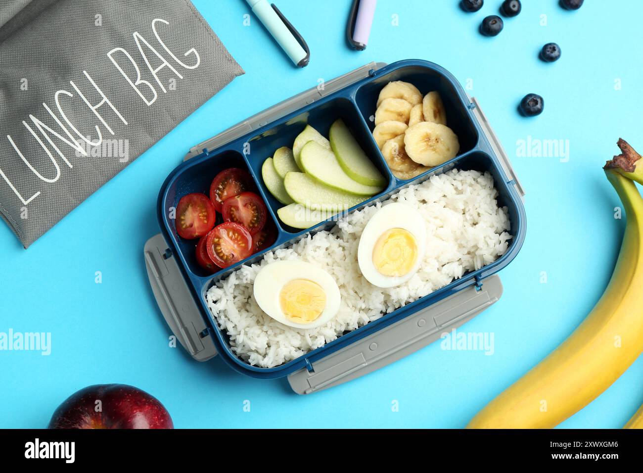 Bag, lunch box with snacks and pens on light blue background, flat lay ...