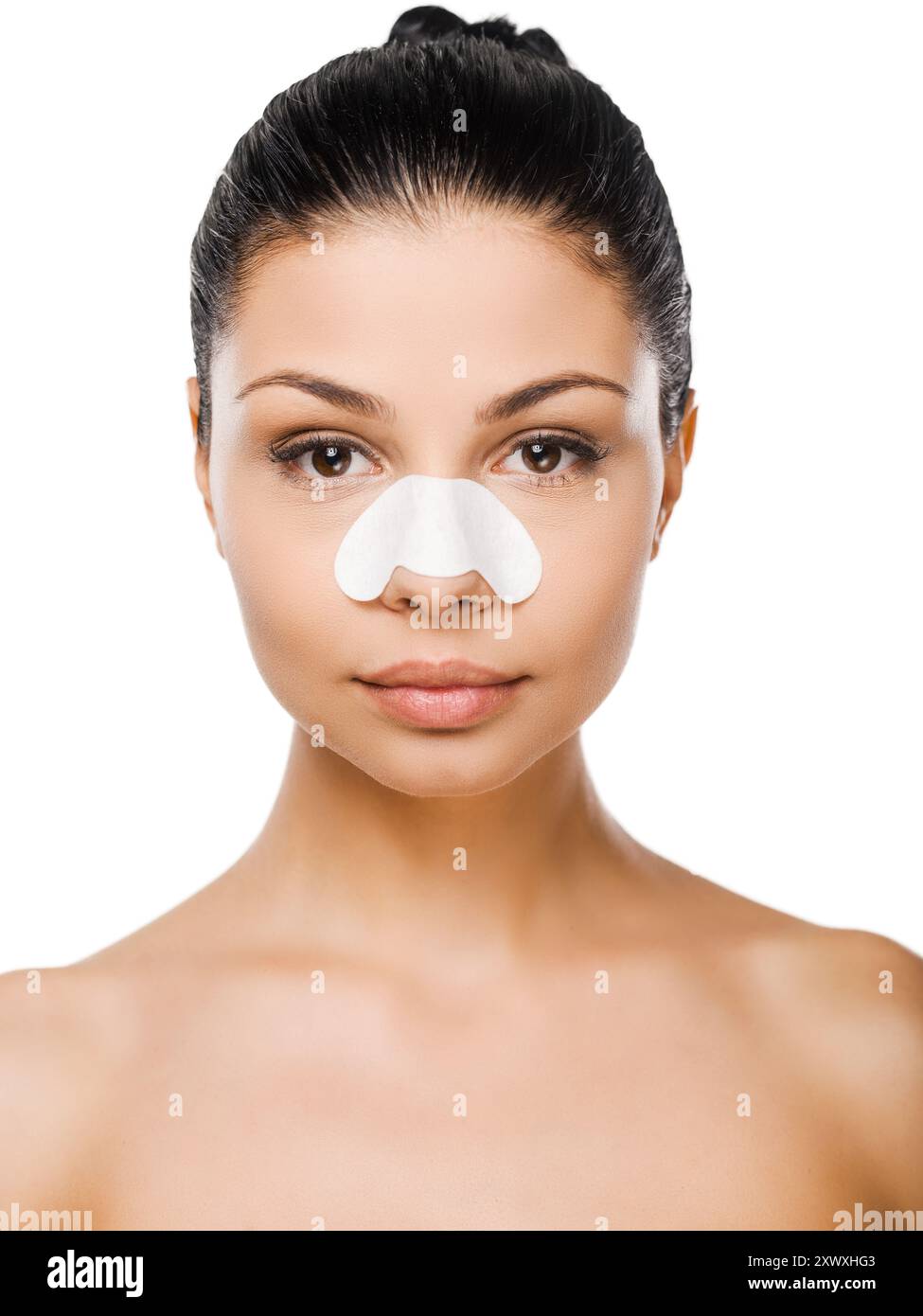 Cleaning her face. Beautiful young woman with clear-up patches on her nose looking at camera ...