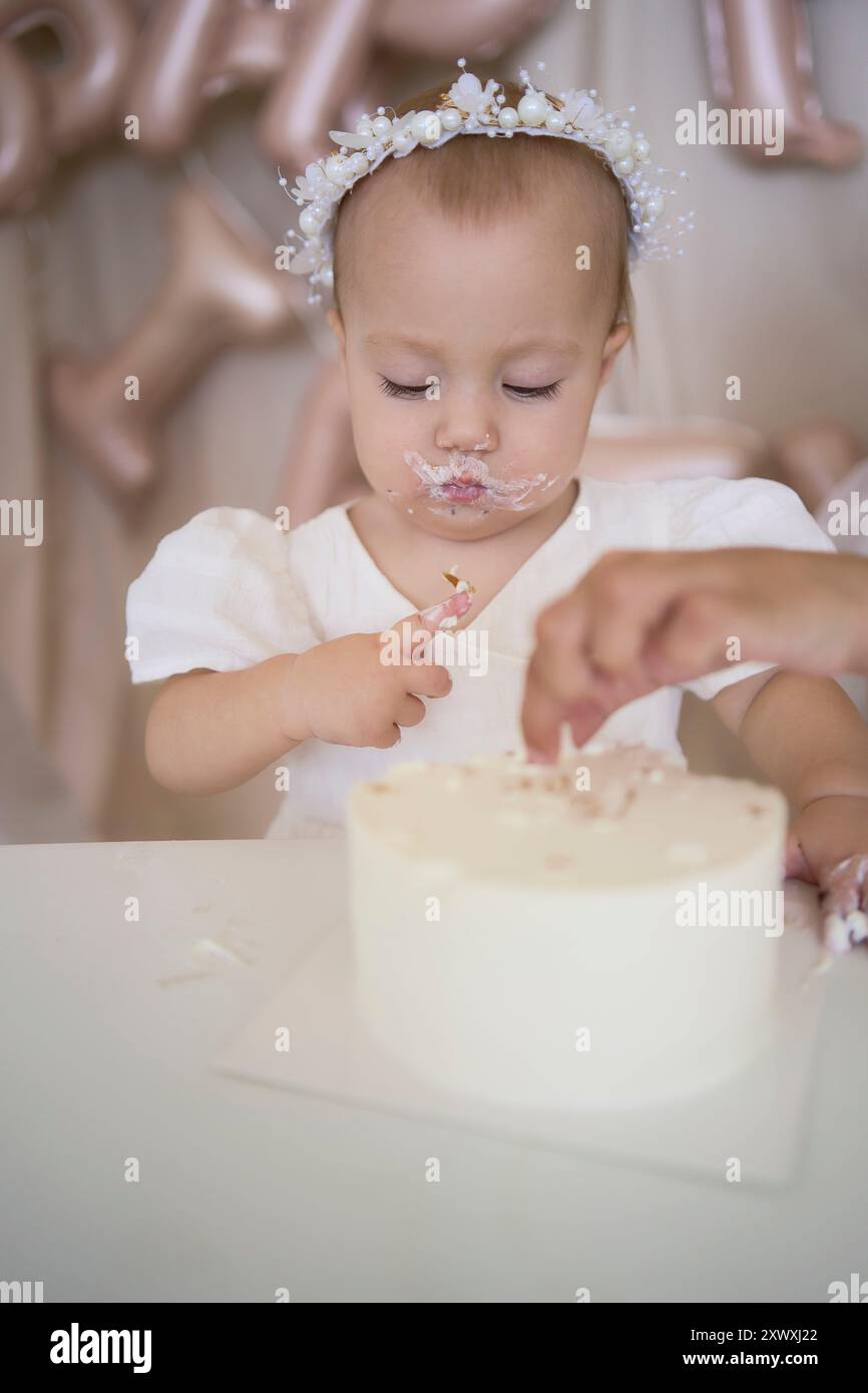 baby girl tries her first birthday cake with mom and pre-teen sister ...