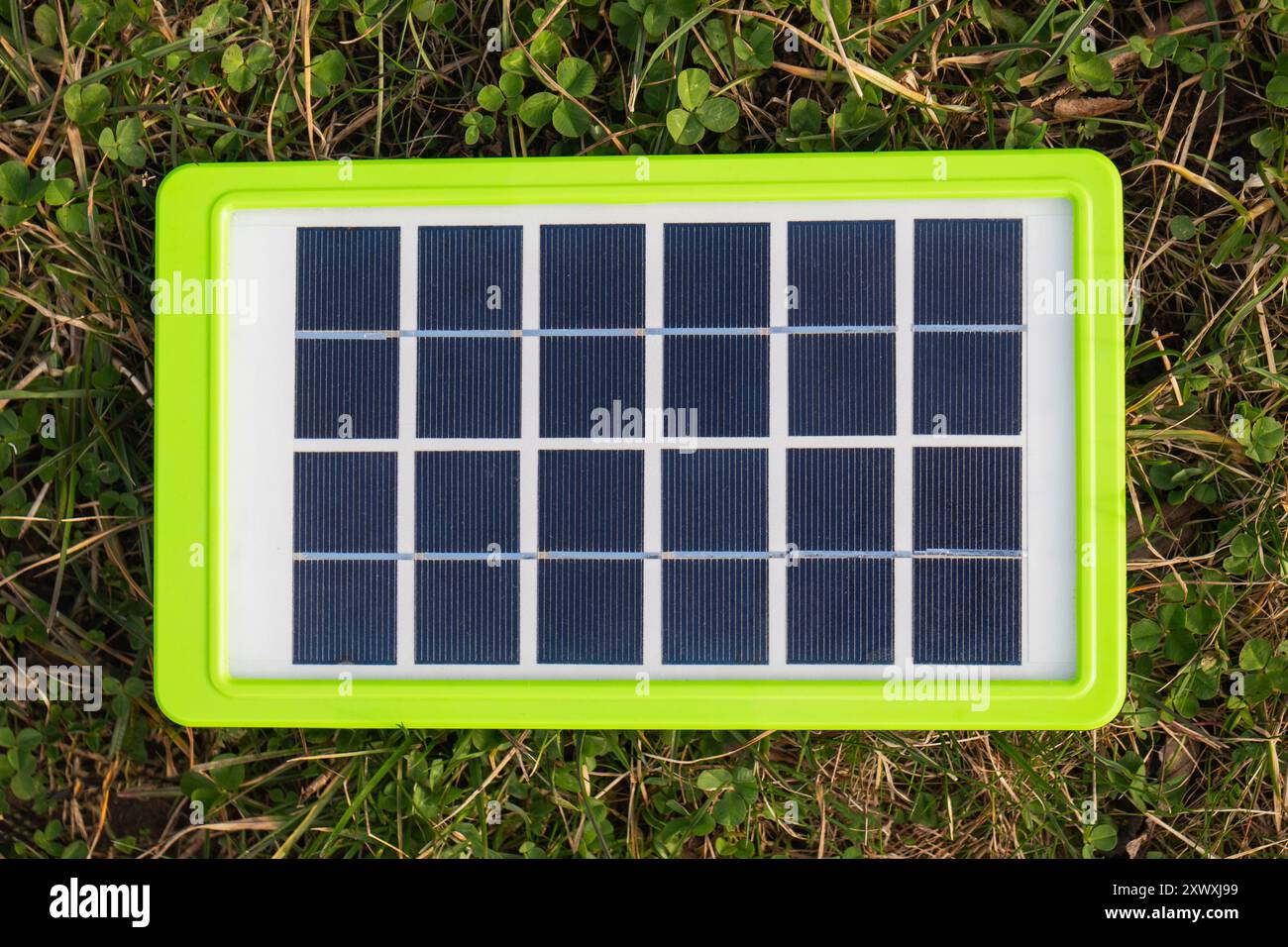 Portable solar panel on green border lying on grass, symbolizing mobile ...