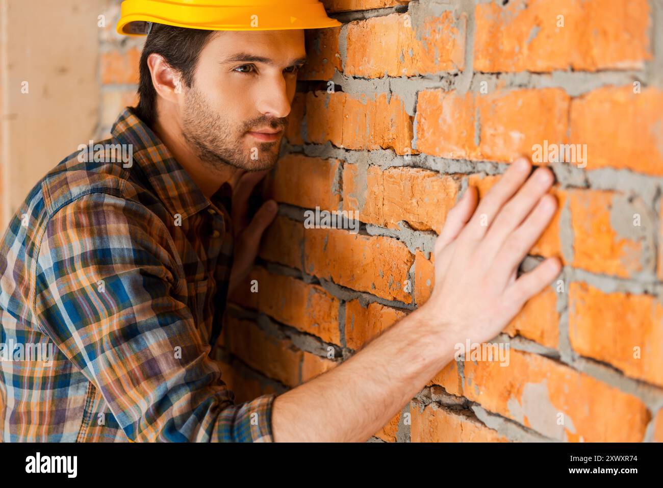 Everything should be perfect. Concentrated young man in hardhat ...
