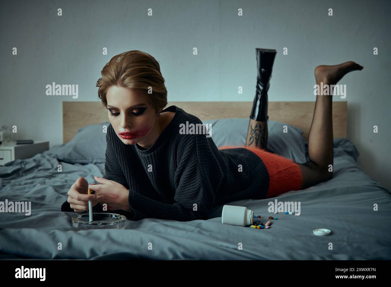 A woman in stylish grunge attire poses on a bed, smoking a cigarette ...
