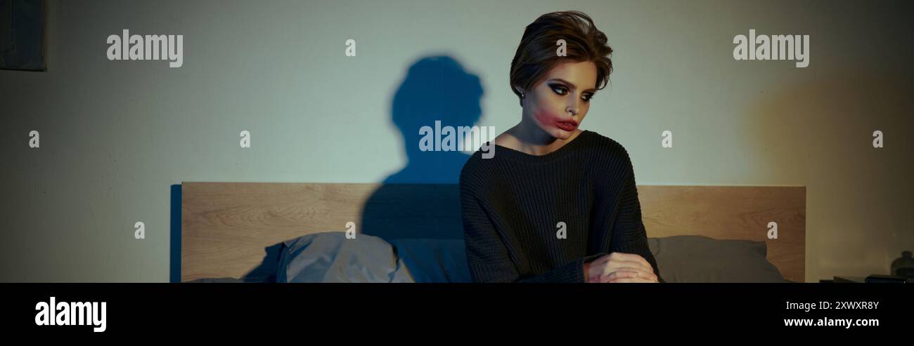 A woman in stylish attire poses on a bed with a dramatic shadow cast ...