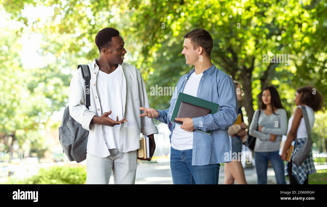 Two international students having conversation at park Stock Photo - Alamy