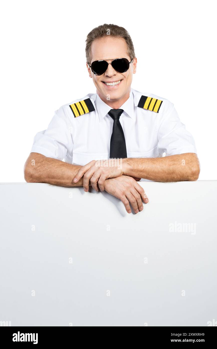 Advertising your airlines. Confident male pilot in uniform leaning at ...