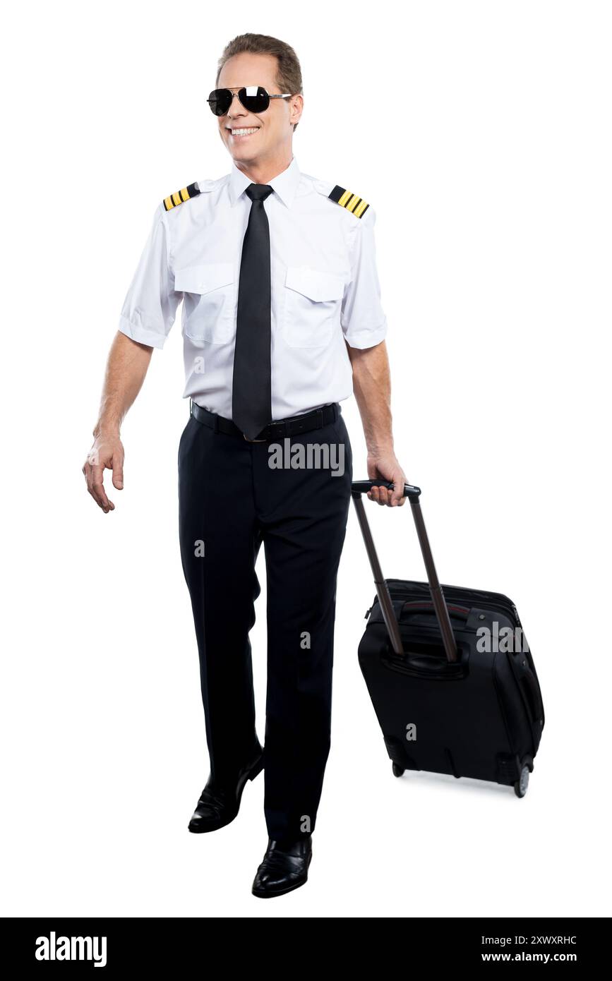 Cheerful pilot. Confident male pilot in uniform walking and carrying ...
