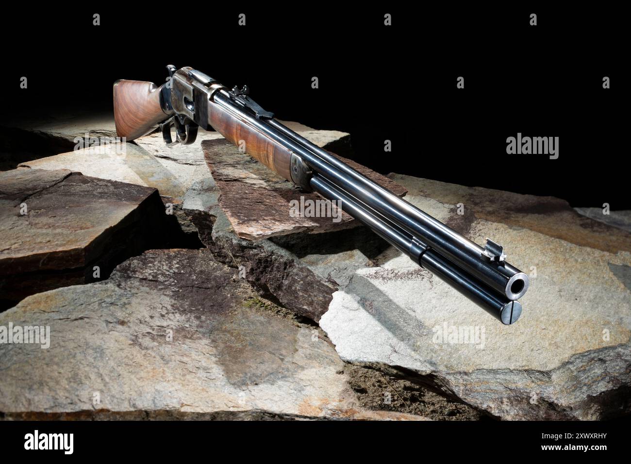 Rifle that is carbine length and lever action on rocks with a dark ...