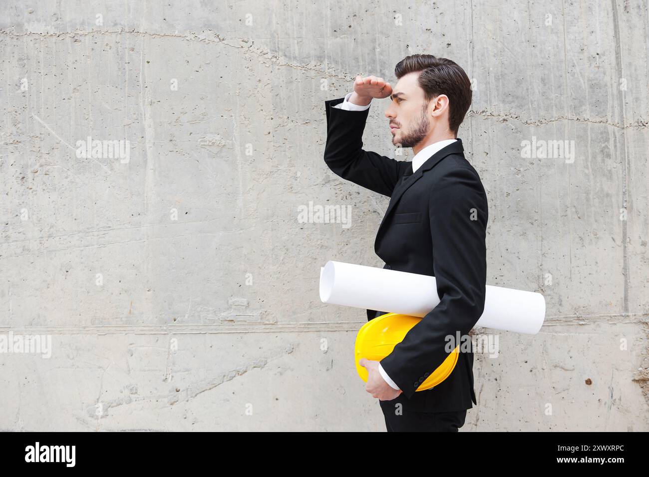 Planning a new construction. Side view of confident young man holding ...