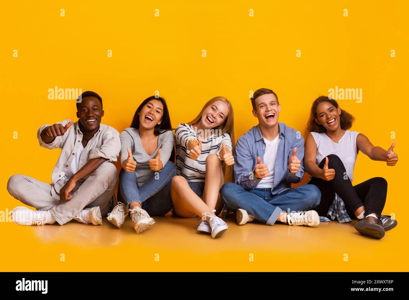 Positive group of international students showing thumbs up Stock Photo ...