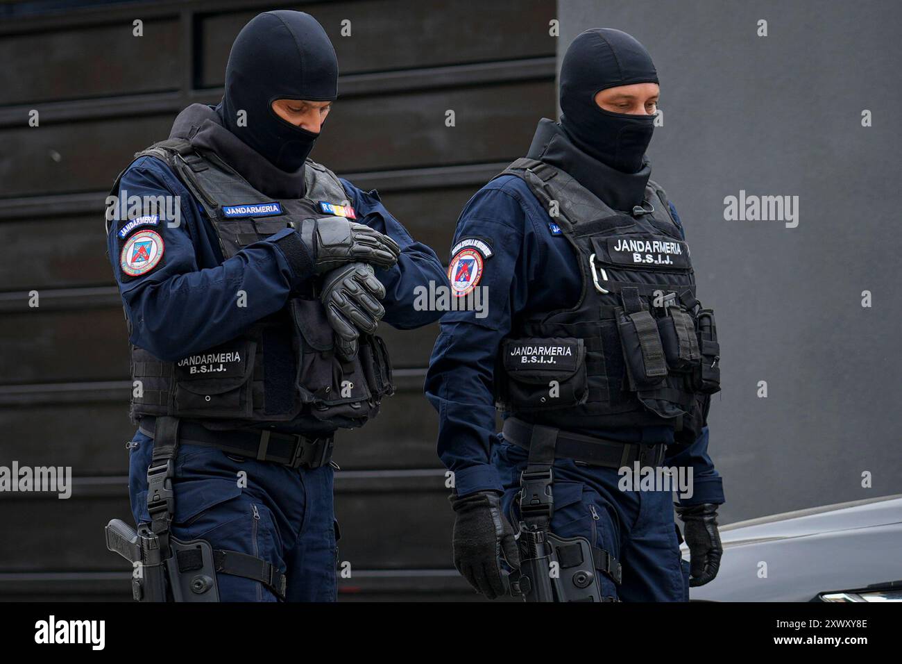 Gendarmes wearing balaclavas walk outside the residence of Andrew Tate ...