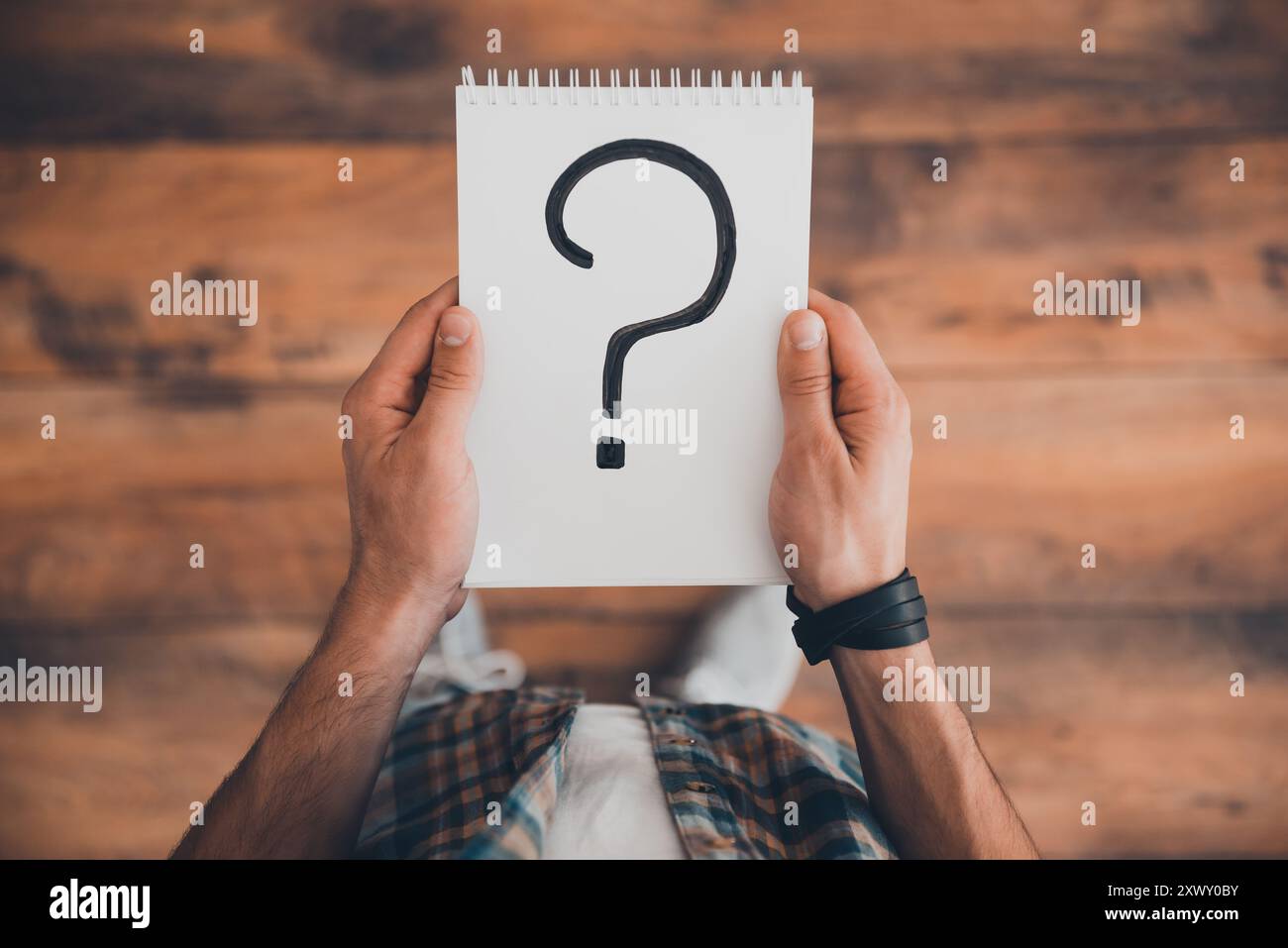 Searching for answers. Top view of man holding note pad with question ...