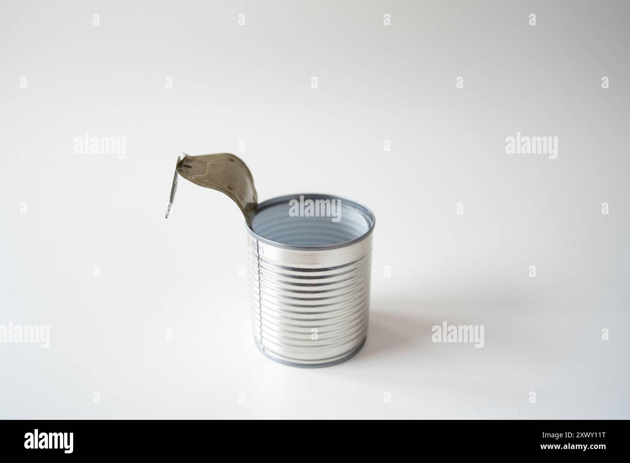 Open lid, unlabeled tin can on white background. Close up shot, no ...