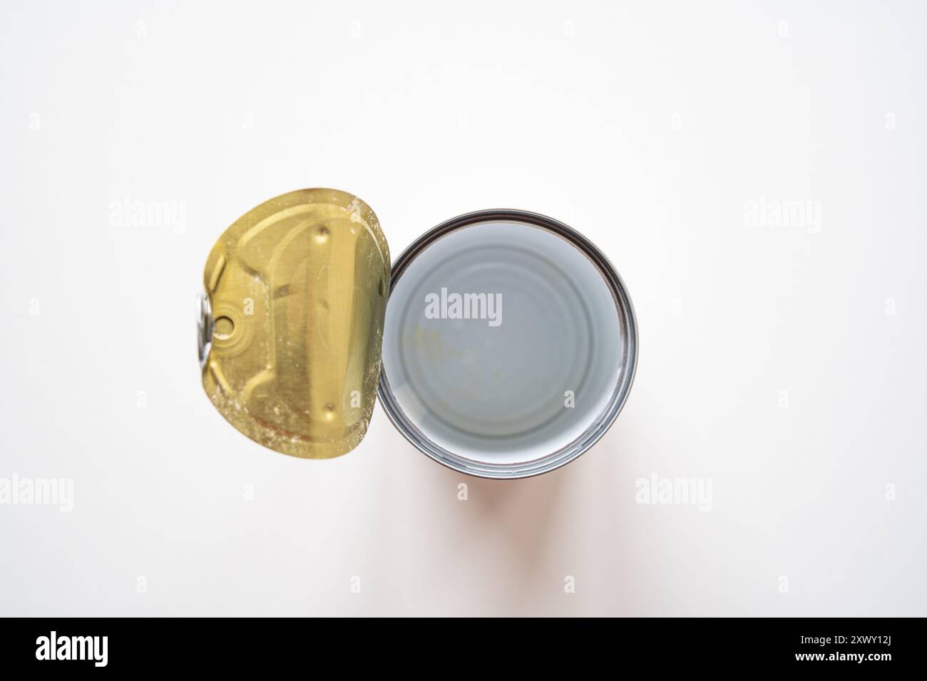 Open lid, unlabeled tin can on white background. Close up shot, no ...