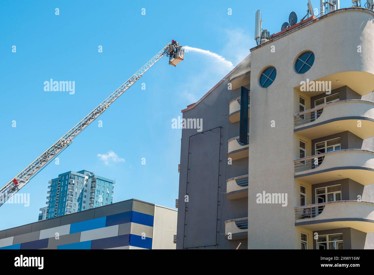 Firefighters extinguish fire on the roof of house using extended ladder ...