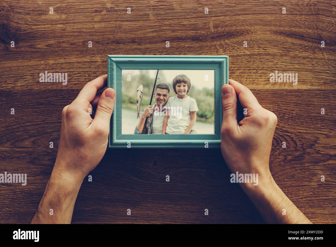 My son is my life. Close-up top view of man holding photograph of ...