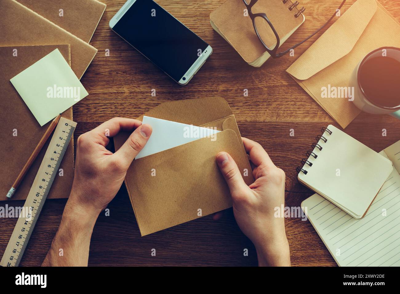 Opening envelope. Close-up top view of male hands opening envelope over ...