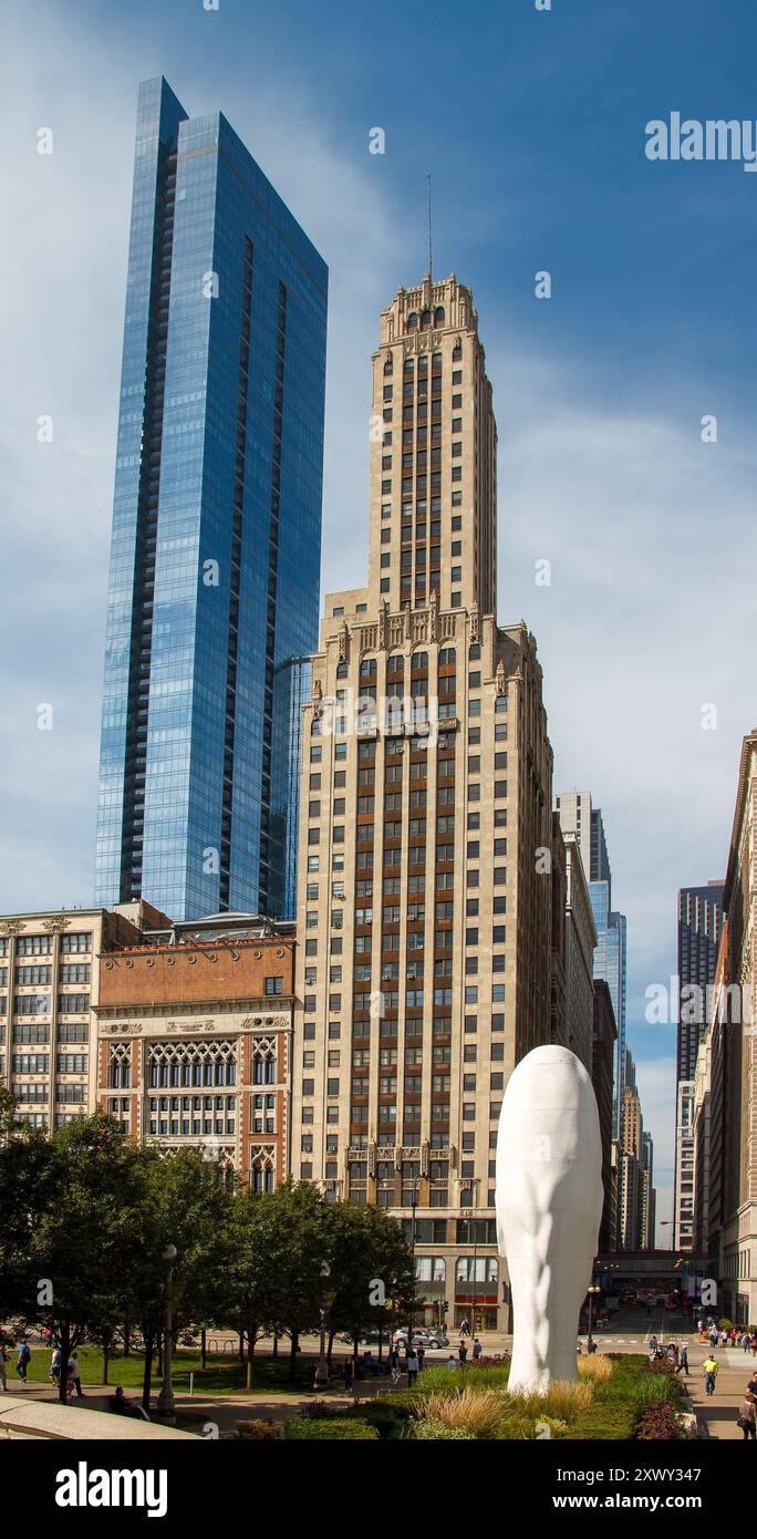 A head statue in Millennium park and the skyline with modern ...