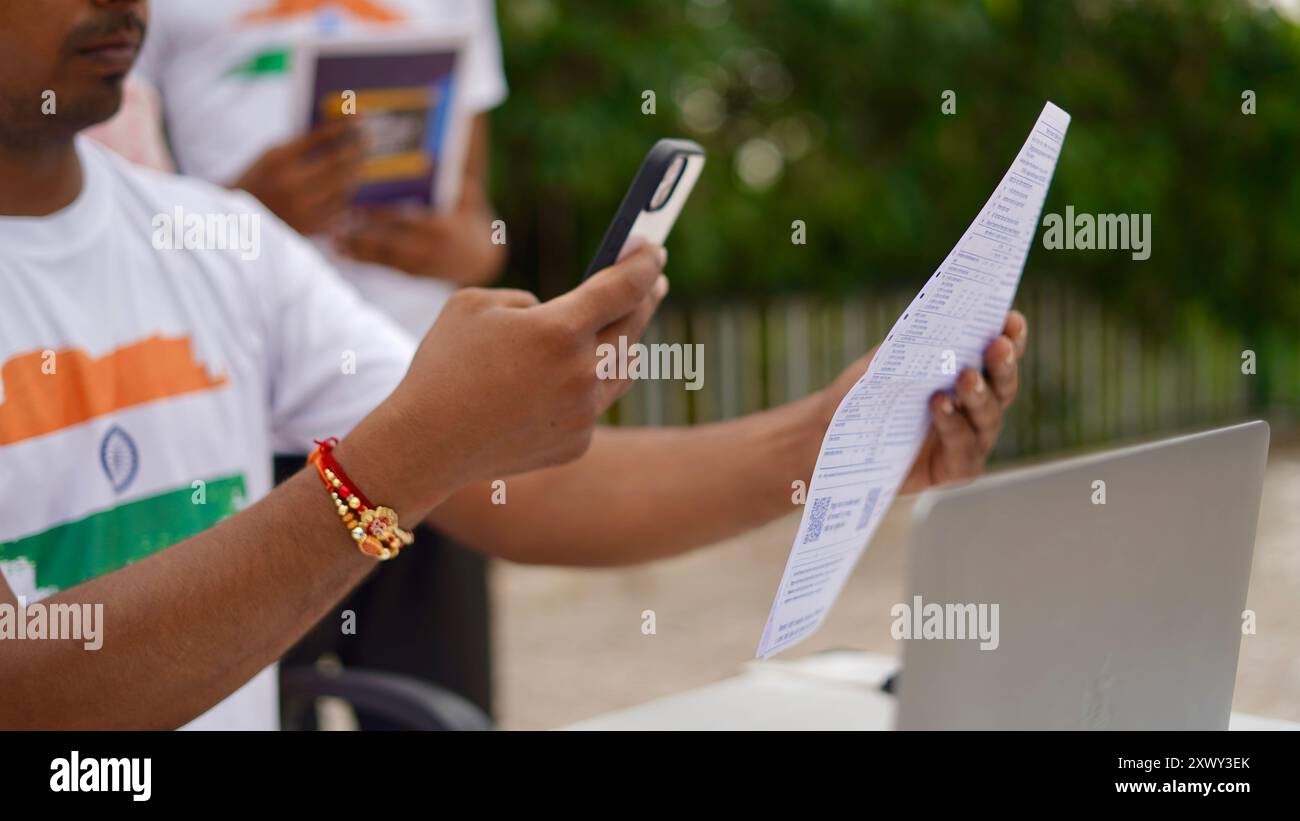 Young Indian man paying bills using mobile and laptop. QR code scan and ...