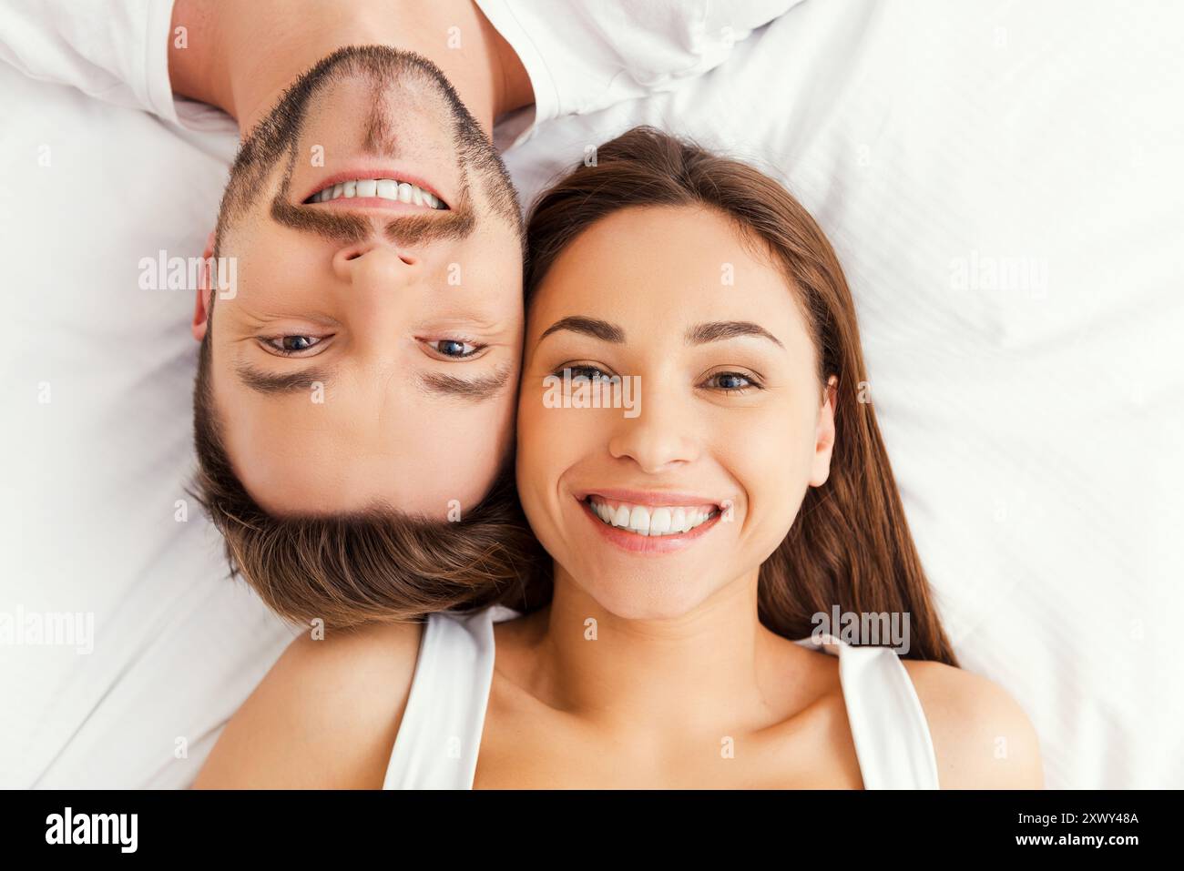 Happy loving couple. Top view of beautiful young loving couple lying in ...