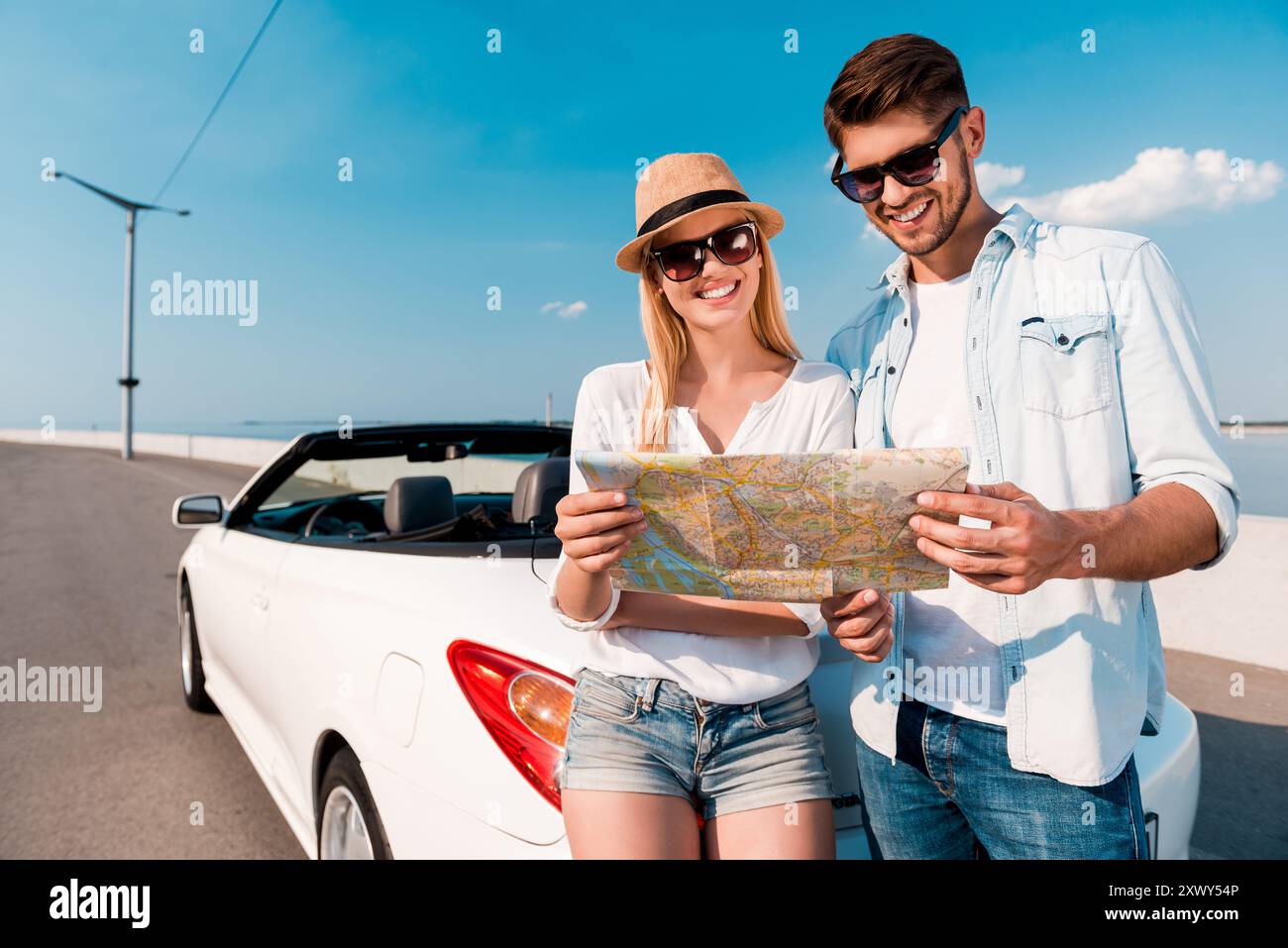 Free to choose our destinations. Joyful young couple examining map ...