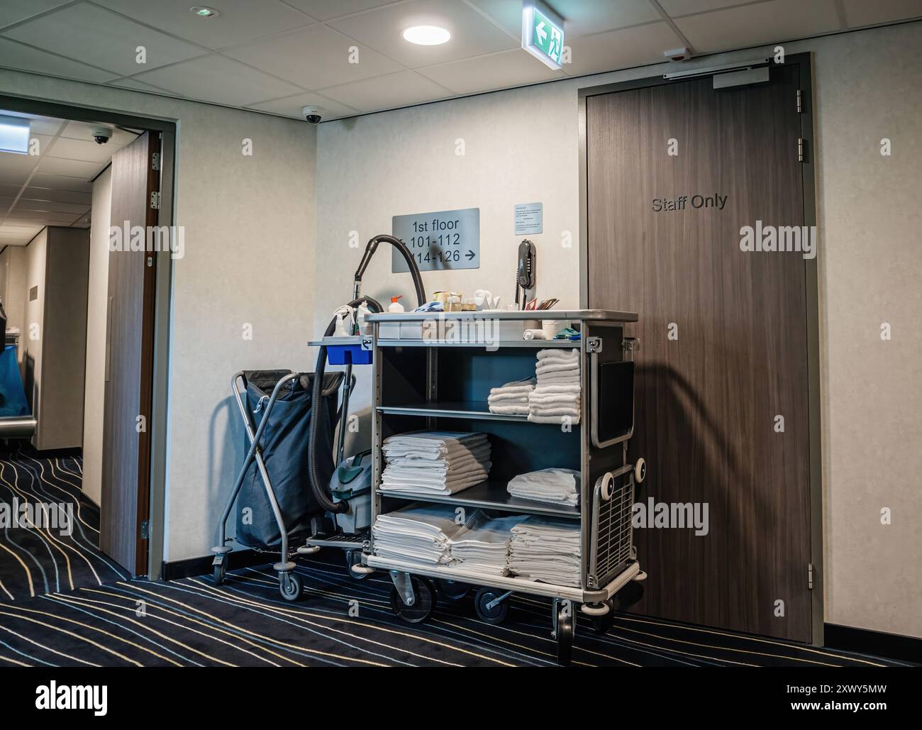A side view of a hotel corridor shows cleaning tools belonging to a ...