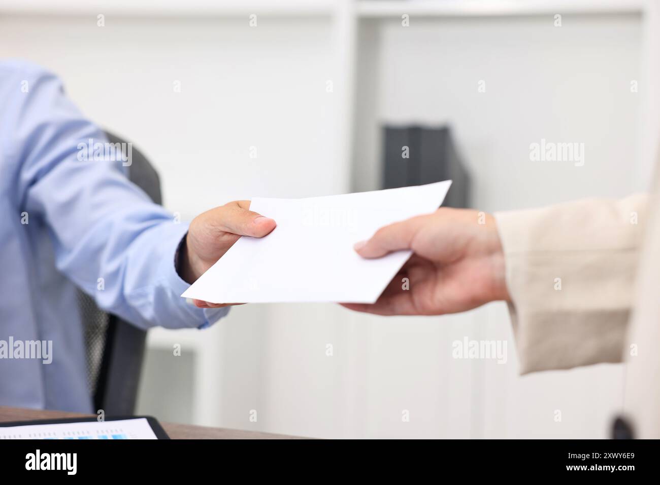 Employee receiving envelope with salary from boss in office, closeup ...