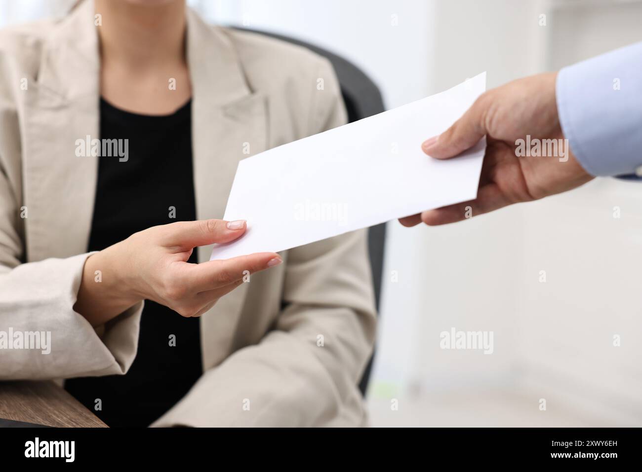 Employee receiving envelope with salary from boss in office, closeup ...