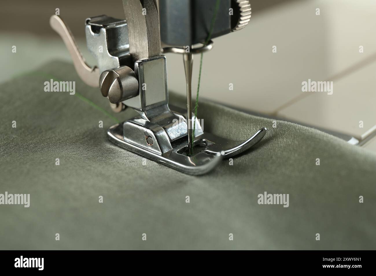 Sewing green fabric with machine, closeup view Stock Photo - Alamy