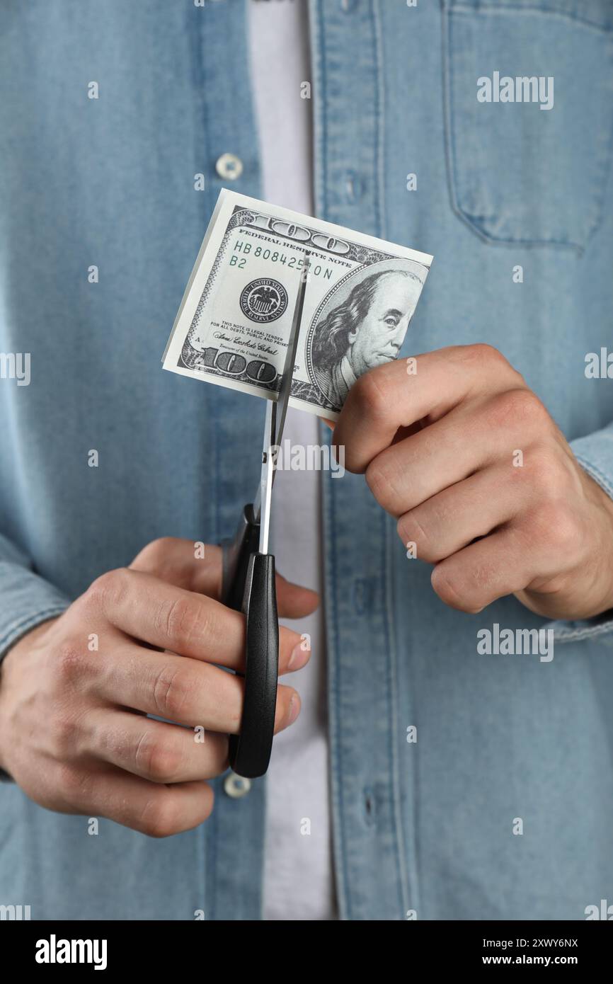 Man cutting dollar banknote hi-res stock photography and images - Alamy
