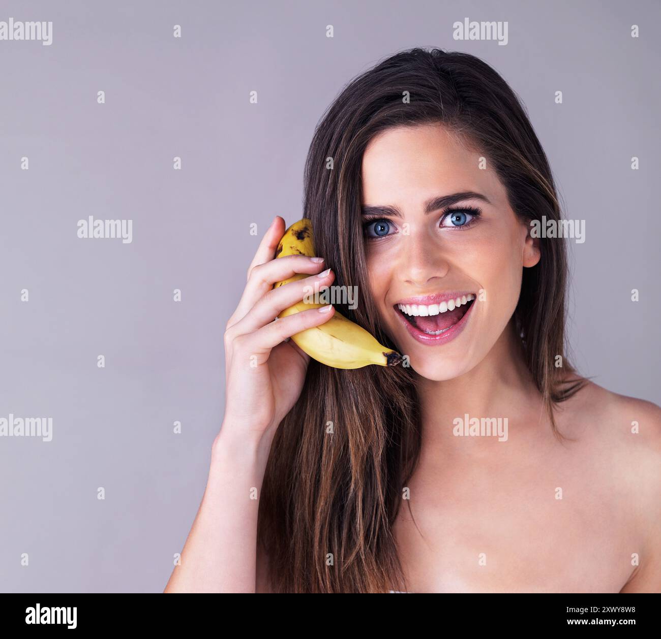 Banana, phone call and portrait of woman in studio for comic, humor and ...