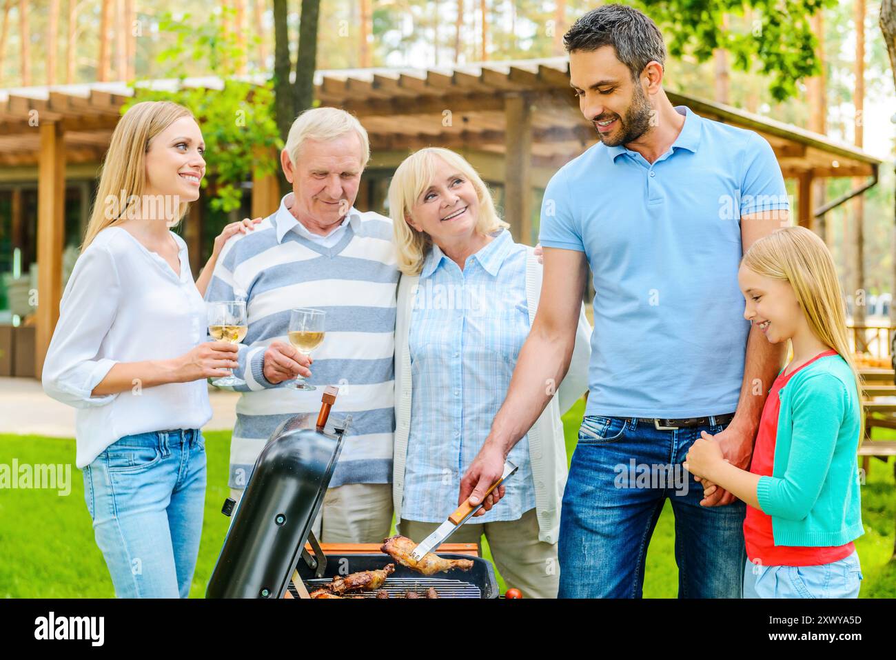 Family barbeque. Happy family of five people barbecuing meat on grill ...